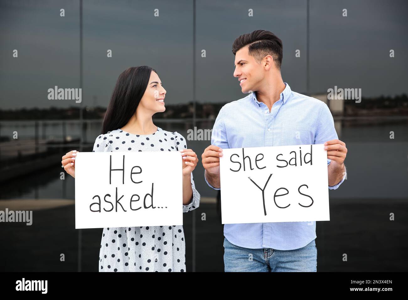 Lovely couple holding posters with text HE ASKED... SHE SAID YES after ...