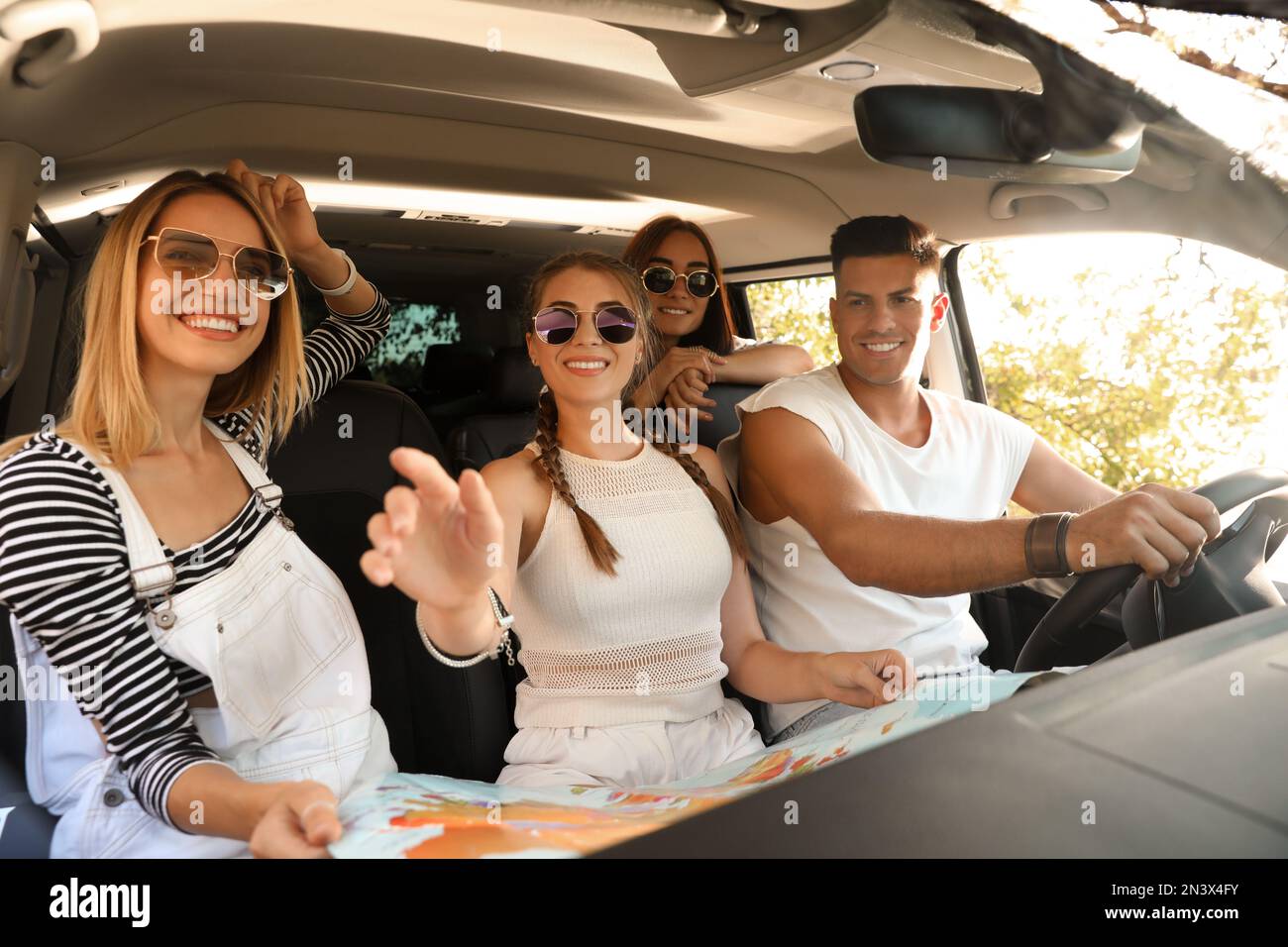 Happy friends together in car on road trip Stock Photo - Alamy