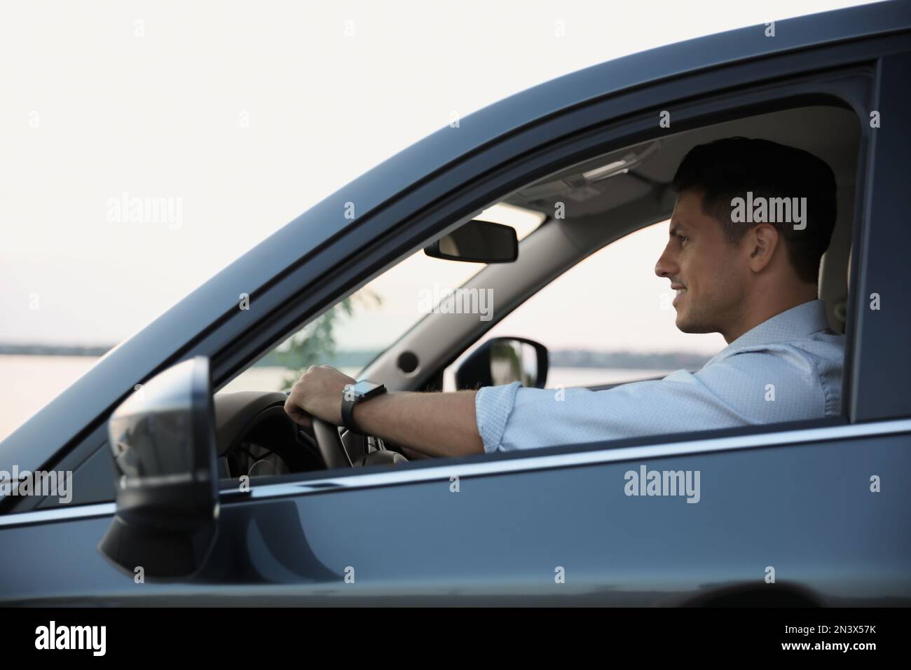 Handsome man driving his modern car, view from outside Stock Photo - Alamy