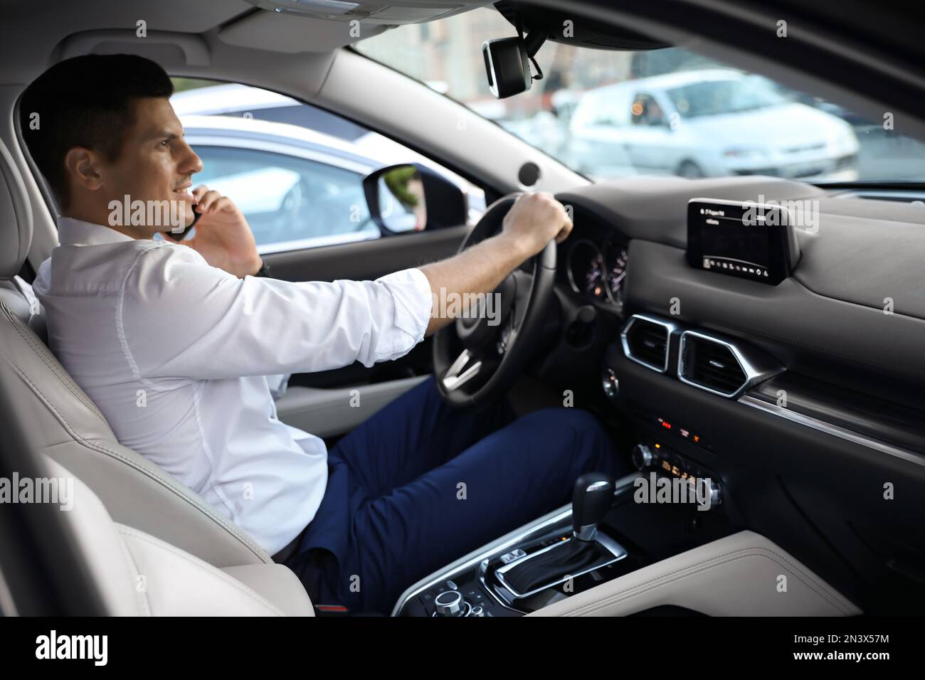 Handsome man talking on phone while driving his modern car Stock Photo ...
