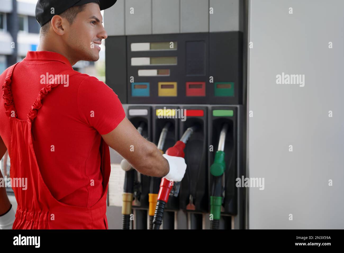 Worker taking fuel pump nozzle at modern gas station Stock Photo - Alamy