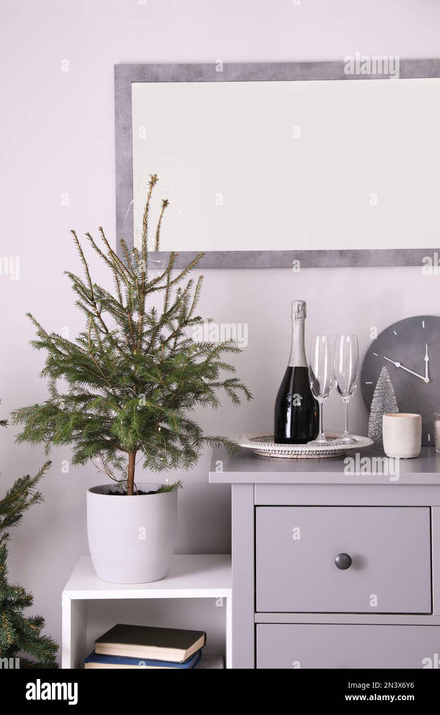Christmas tree and decor on chest of drawers indoors. Interior design ...