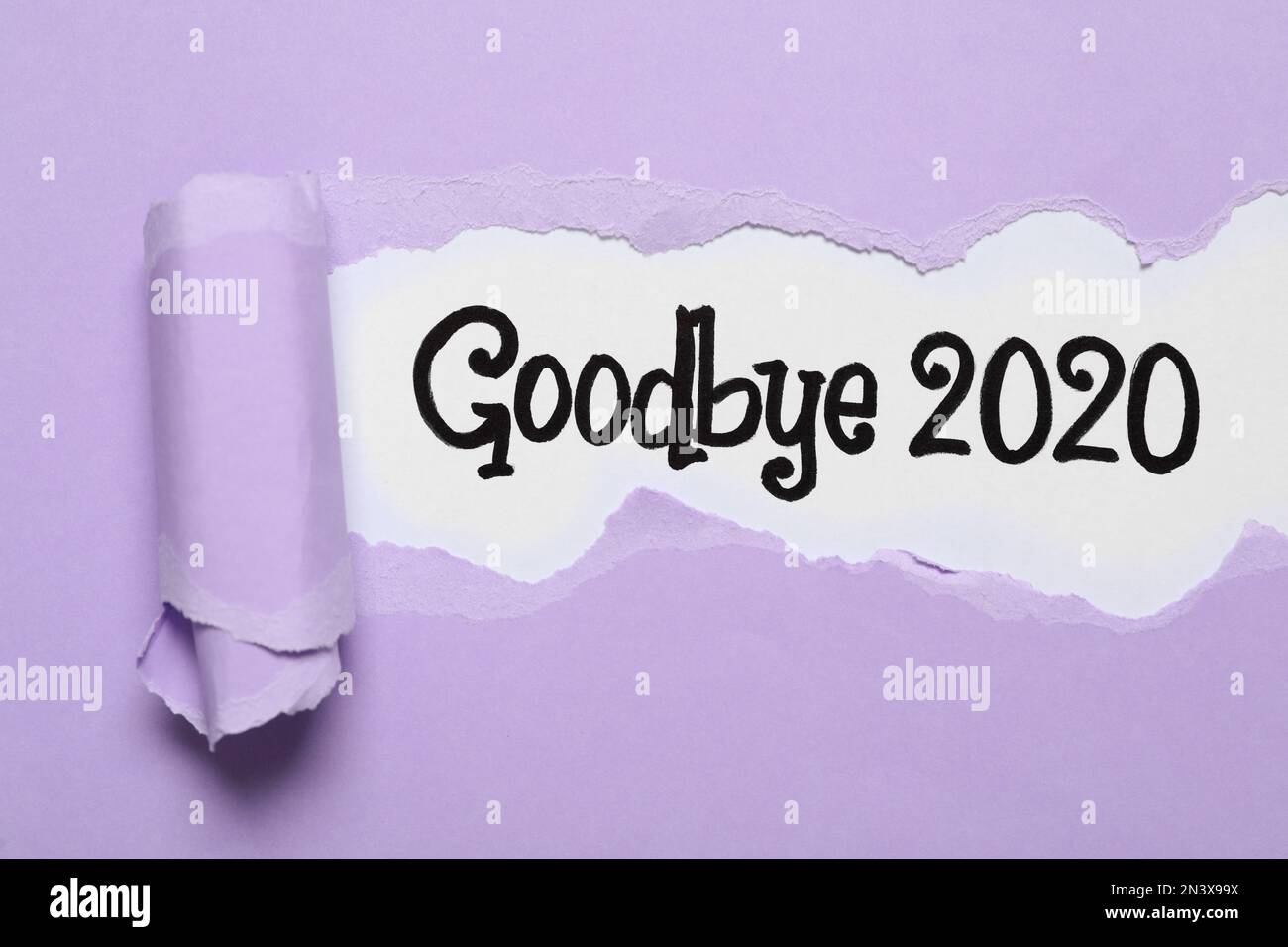 Text Goodbye 2020 on white background, top view through torn lilac ...