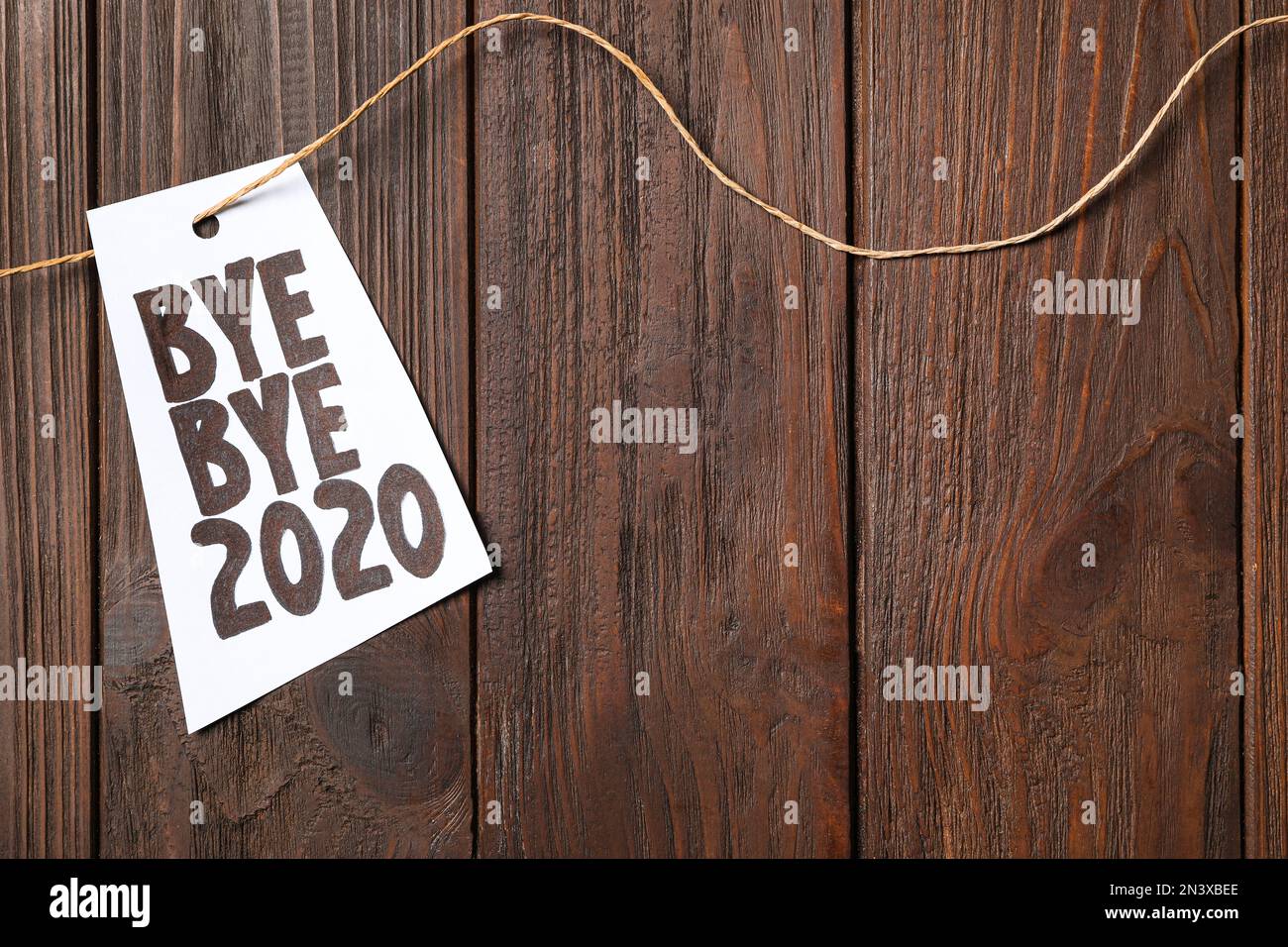Sheet of paper with phrase Bye Bye 2020 on wooden table, top view ...