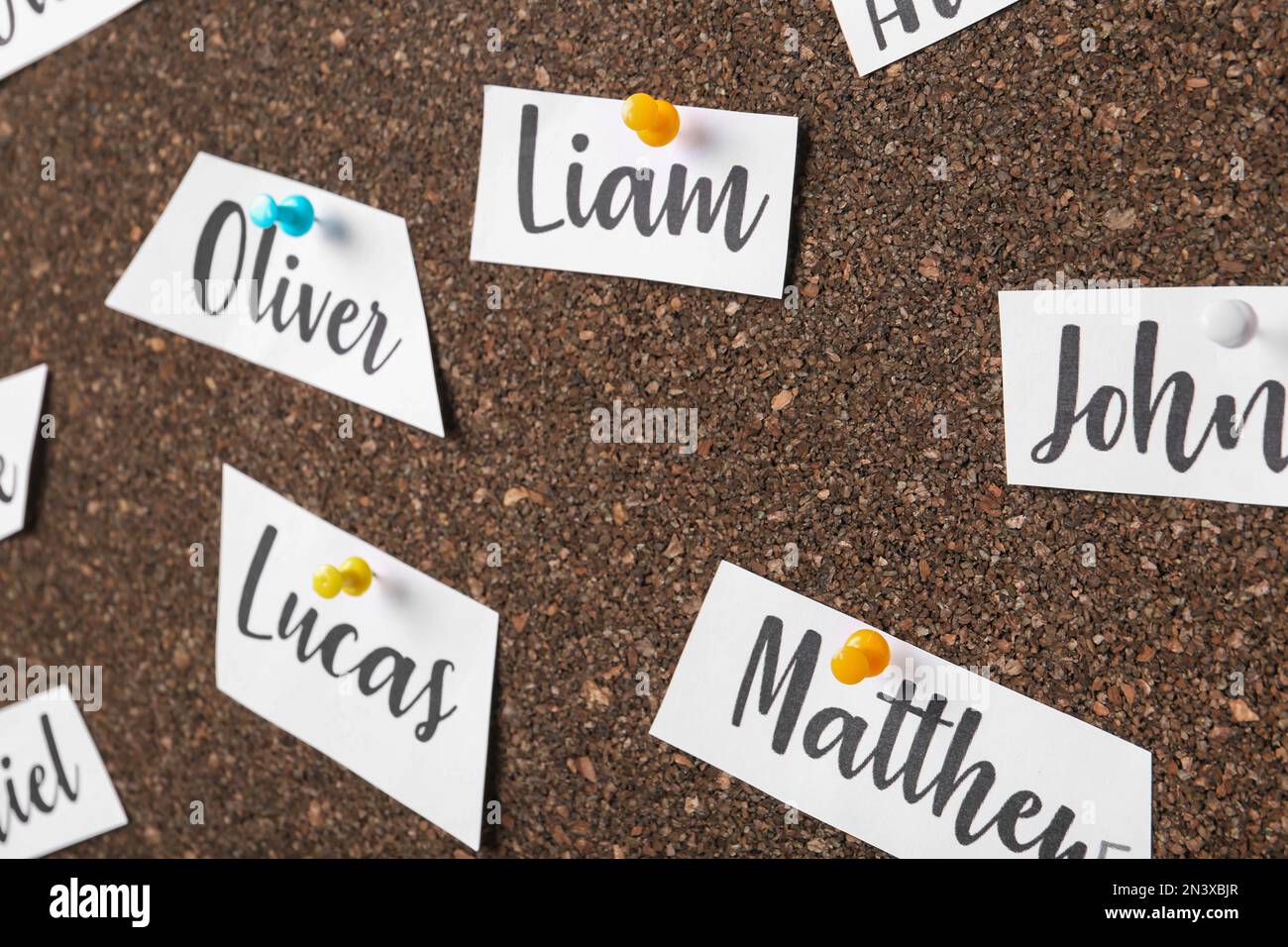 Paper pieces with baby names on cork board, closeup Stock Photo - Alamy