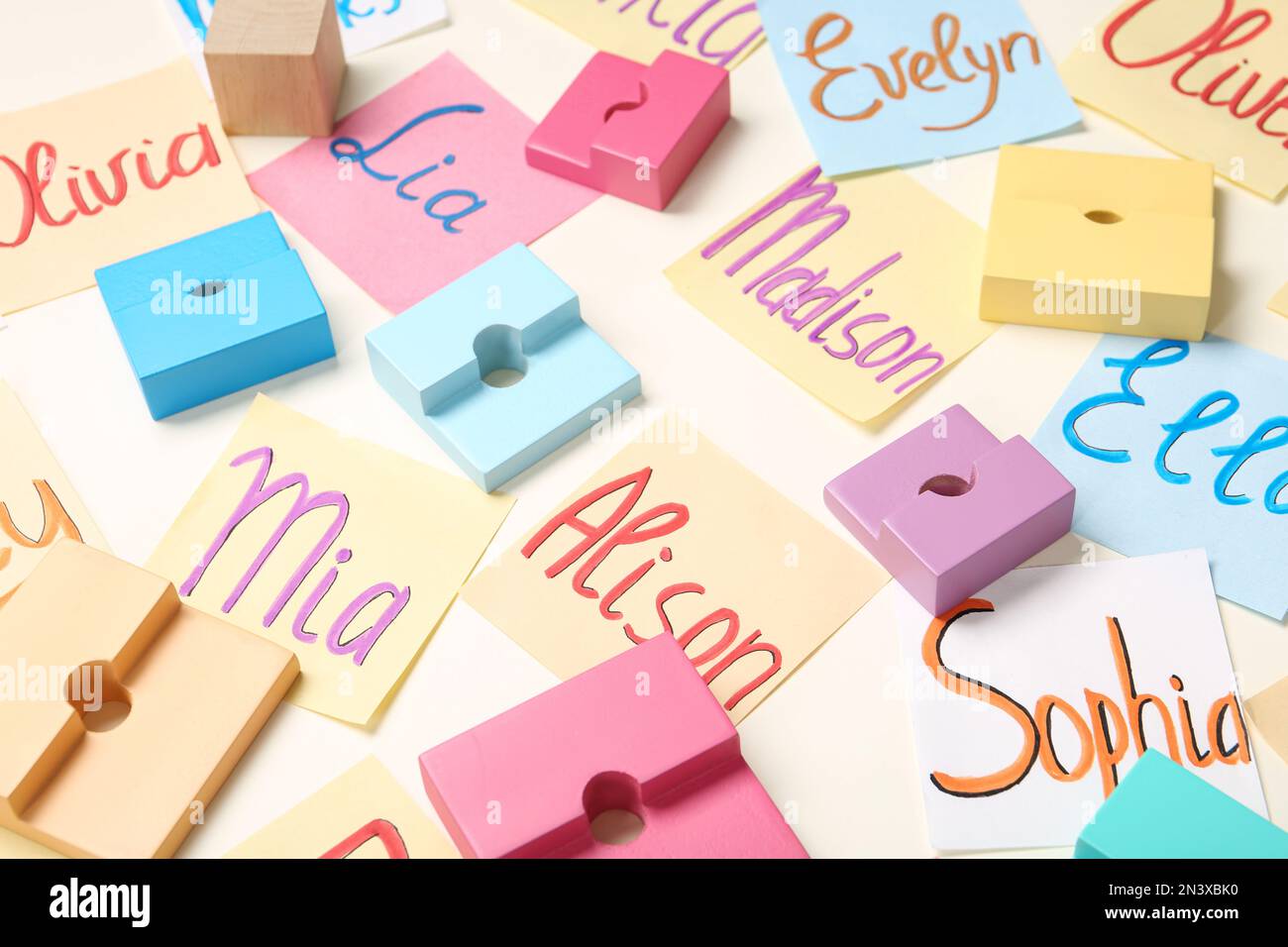 Colorful paper sheets with written different baby names and toys on ...