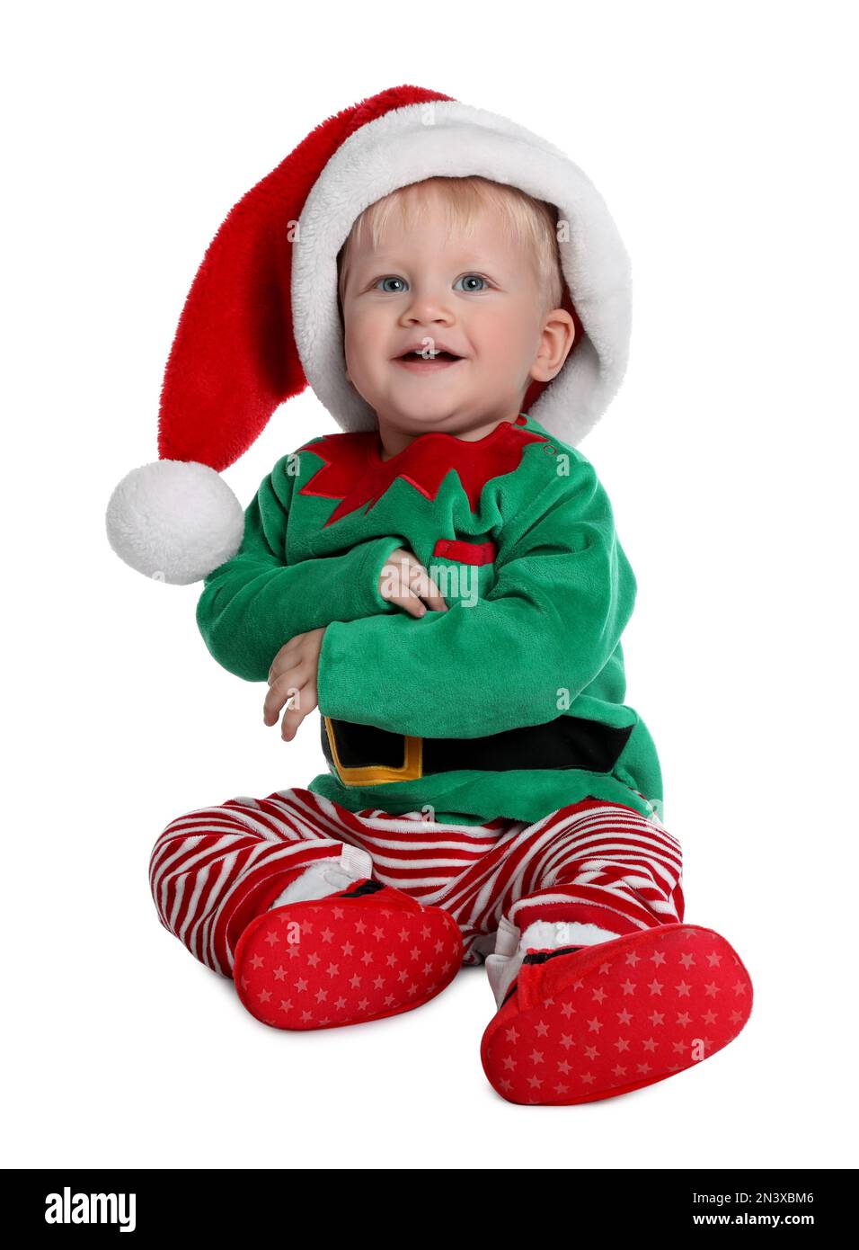 Cute baby in Santa's elf clothes sitting on white background. Christmas ...