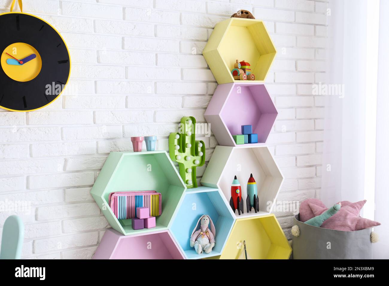 Colorful shelves near brick wall in child room interior Stock Photo - Alamy