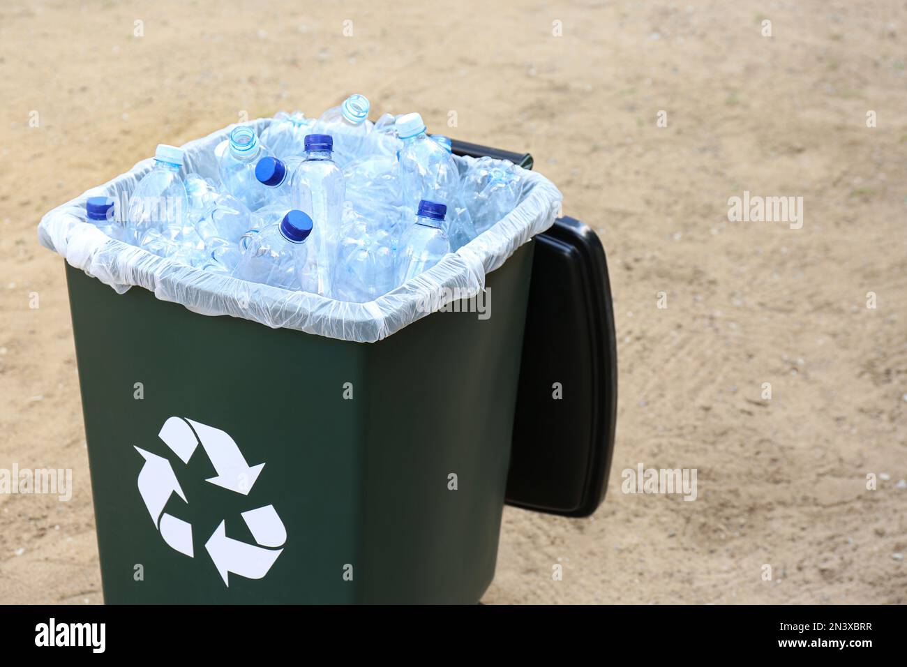 Many used plastic bottles in trash bin outdoors. Recycling problem ...