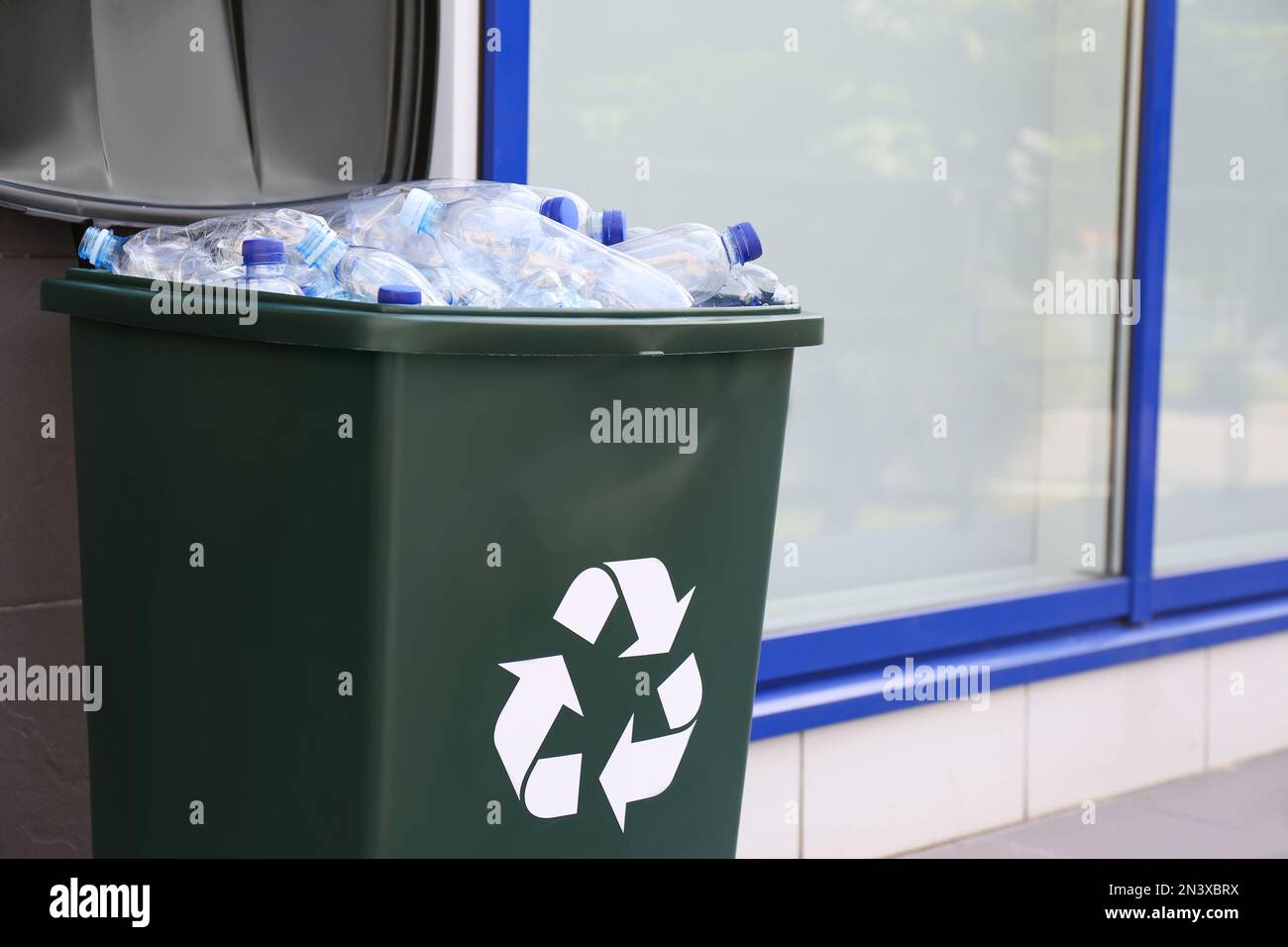 Many used plastic bottles in trash bin outdoors. Recycling problem ...