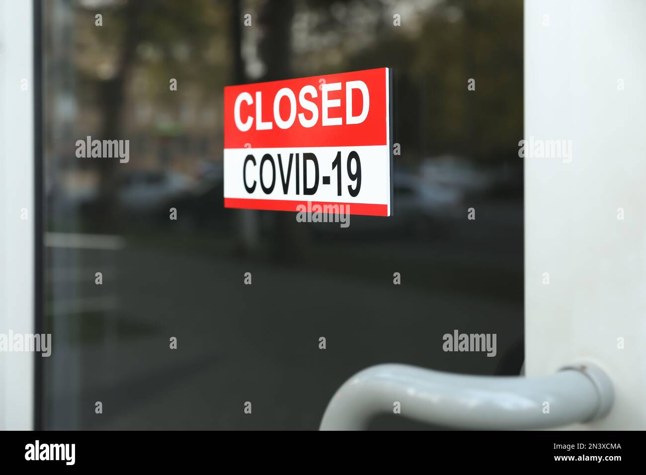 Red sign with words "Closed Covid-19" hanging on glass door Stock Photo ...