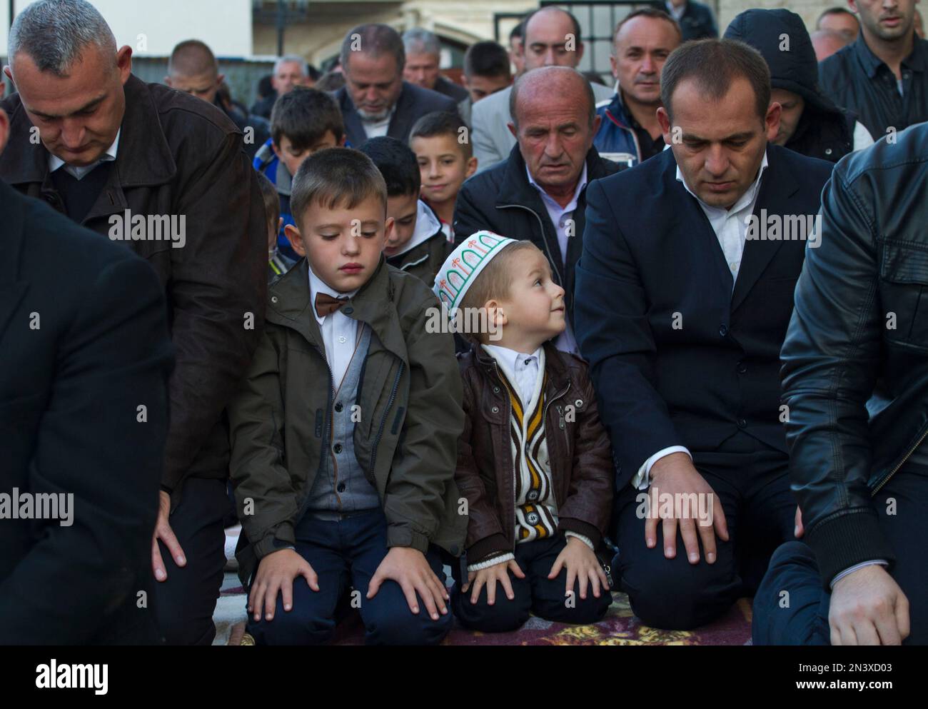 Kosovo boy looks at his father offering Eid al-Adha prayers outside Sultan Mehmet Fatih grand ...