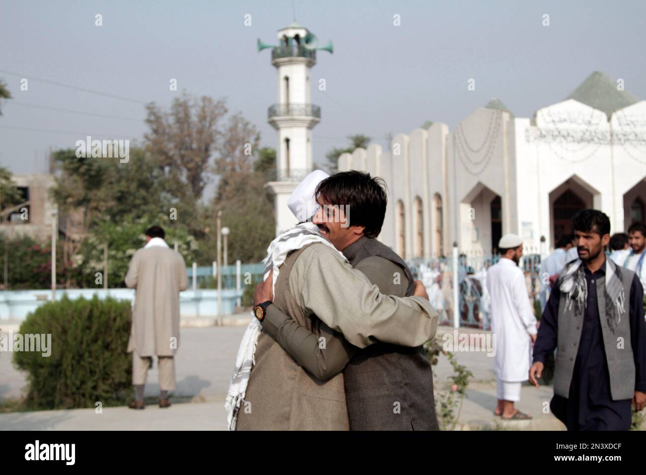 Afghans hug each other after offering Eid al-Adha prayers outside a ...