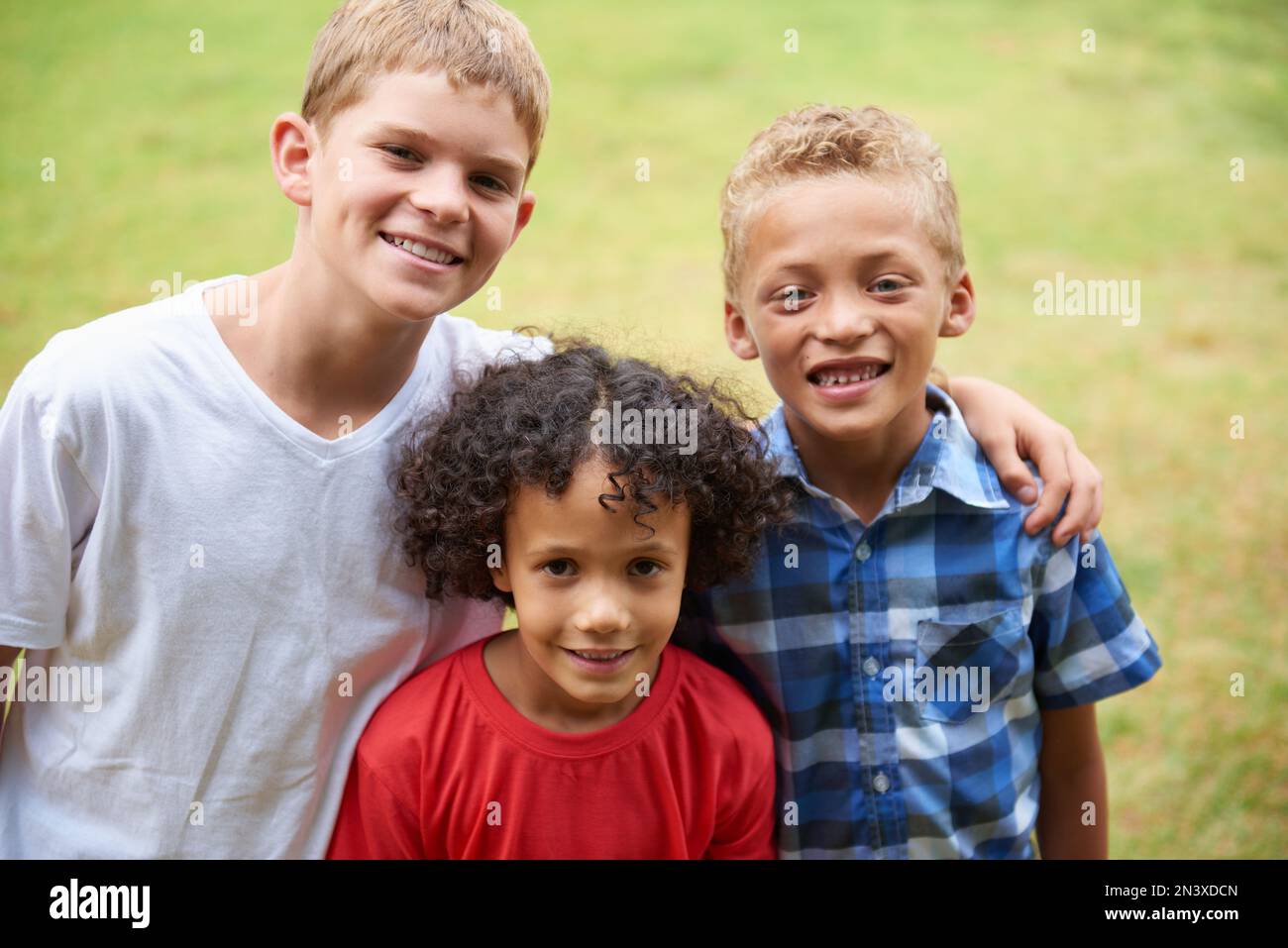 Sunny day friends. Portrait of a three little boys standing outside ...