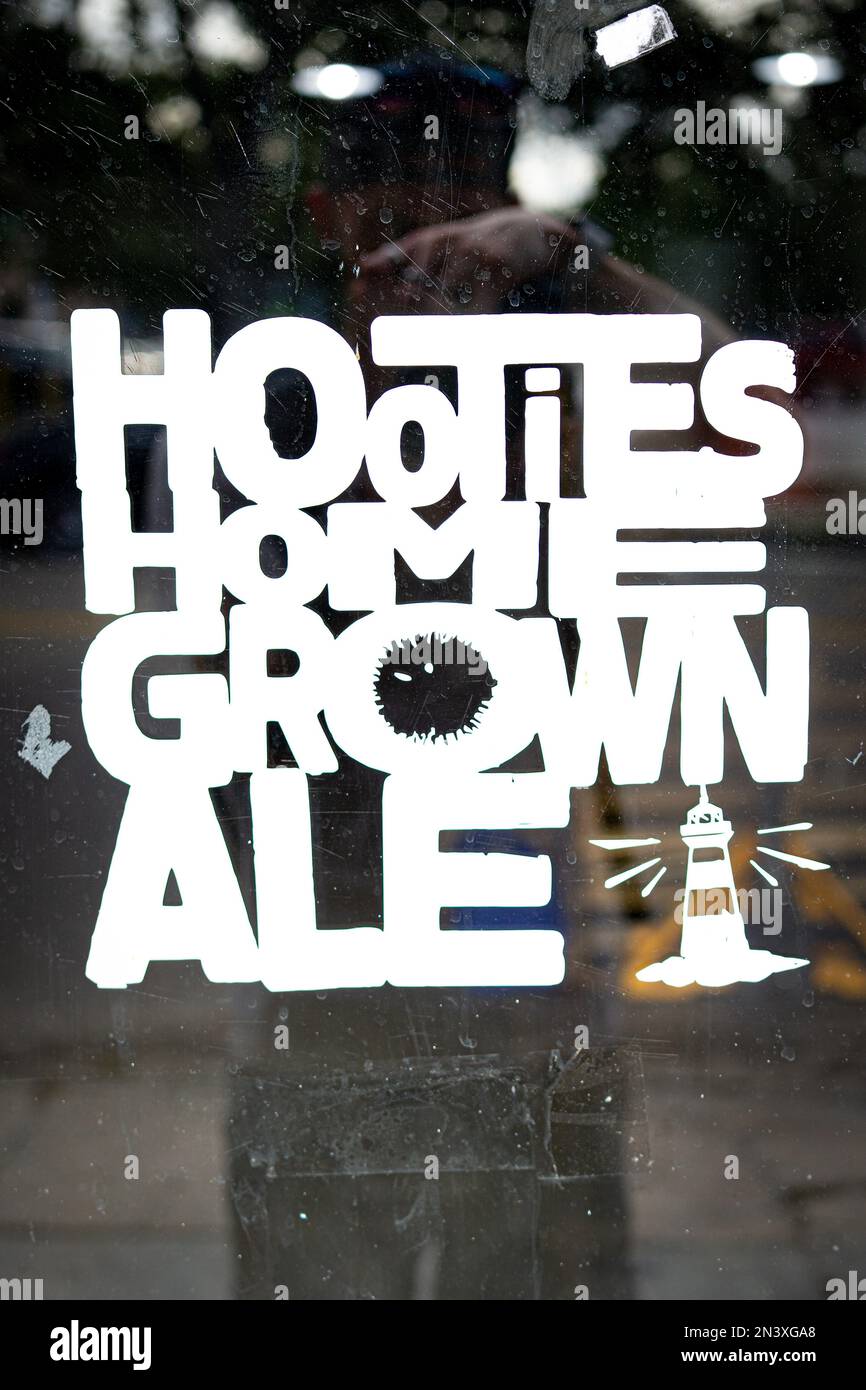 A closeup of Hooties Homegrown Ale sign on a window at the historical ...