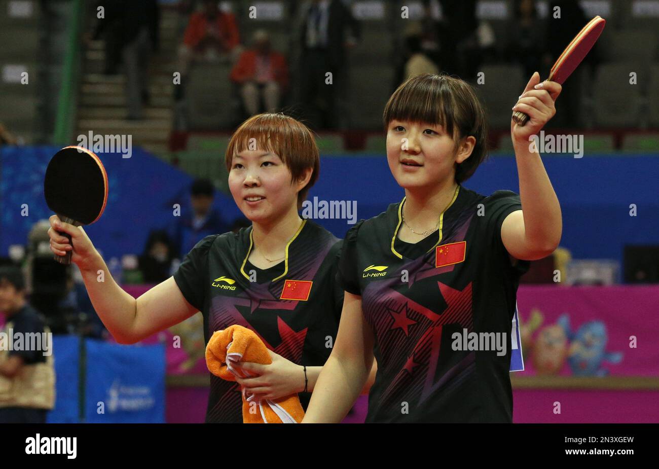 Gold medallists China's Zhu Yuling and Chen Meng, right, celebrate their gold in the table ...