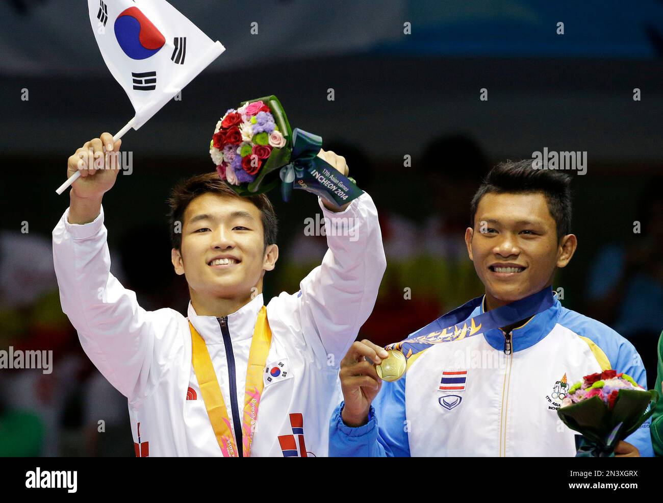 Thailand's Wuttichai Masuk holds his gold medal after defeating South Korea's Lim, left ...