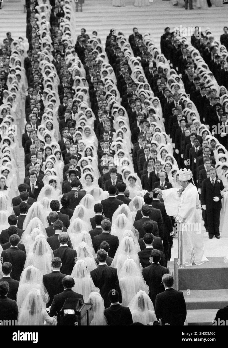 The Reverend Sun Myung Moon, lower left, sprinkles holy water over ...