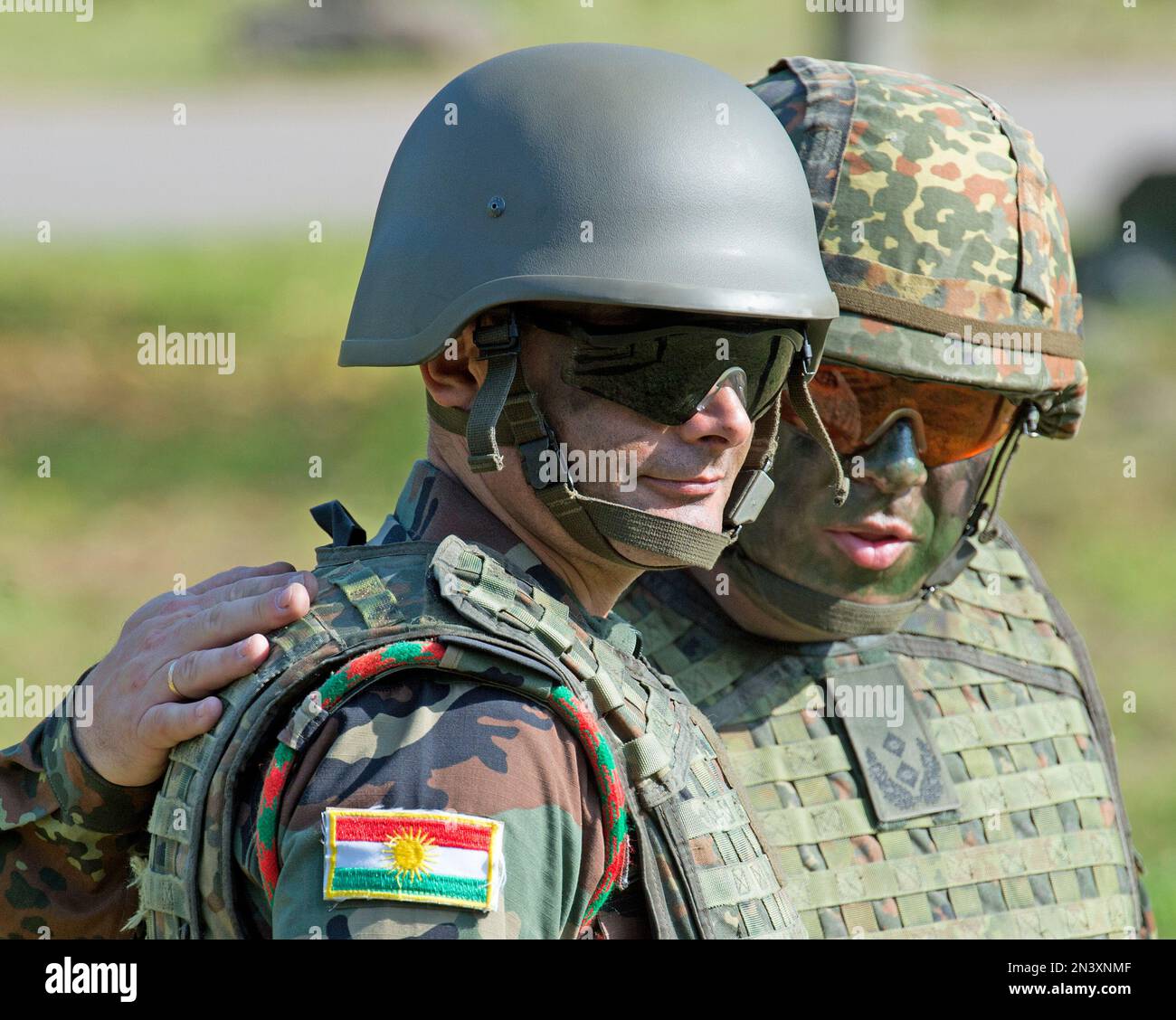 A German sodier, right, puts his hand on the shoulder of a Kurdish ...