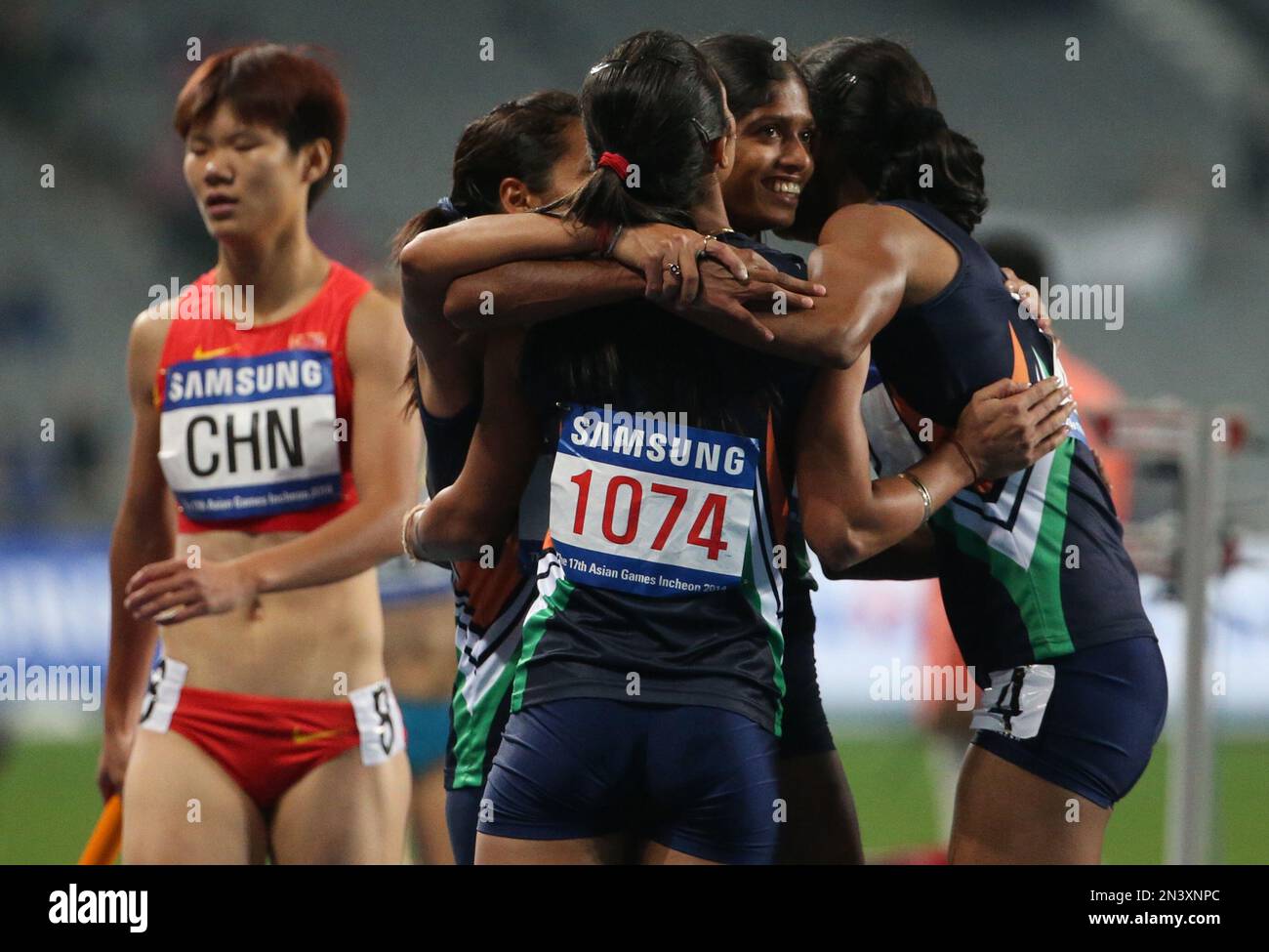 Indian team members huddle after finishing first in the women's 4 x ...