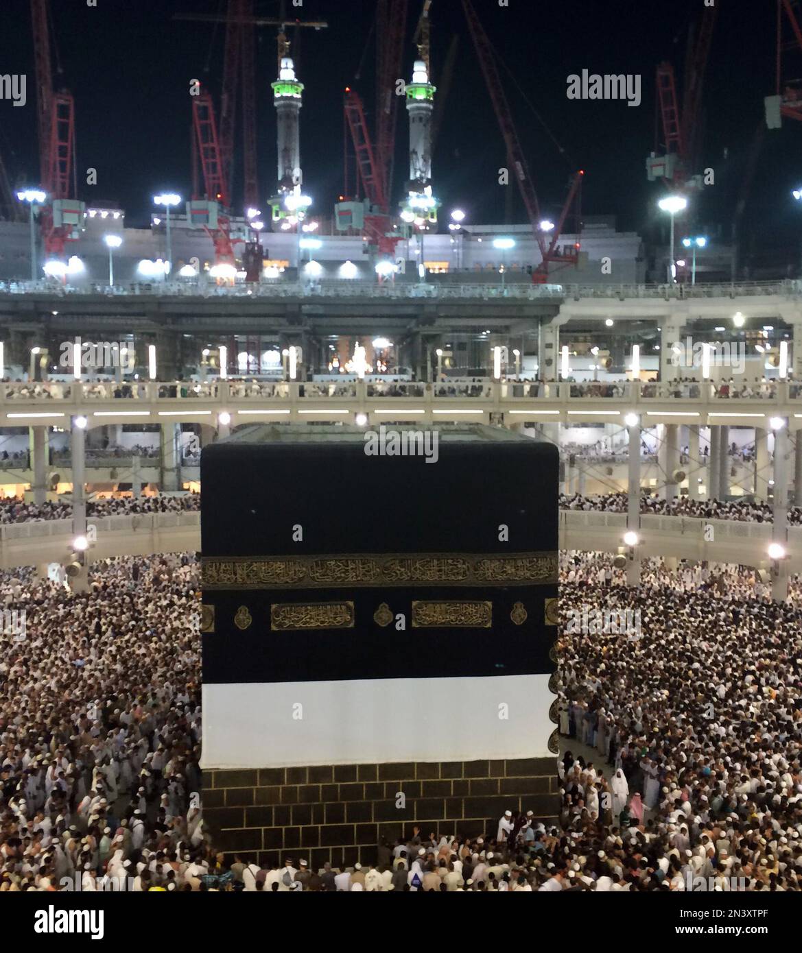 Muslim pilgrims moving around the Kaaba, the black cube at center ...