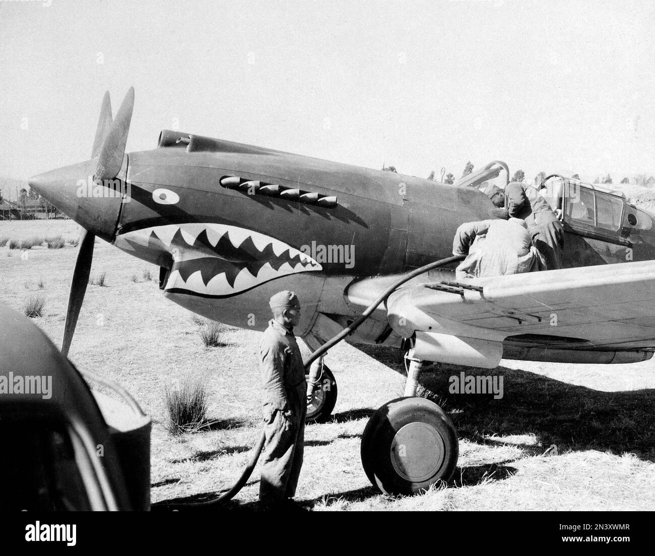 Ammunition is loaded into the wing guns of a U.S. P-40, or Tomahawk ...