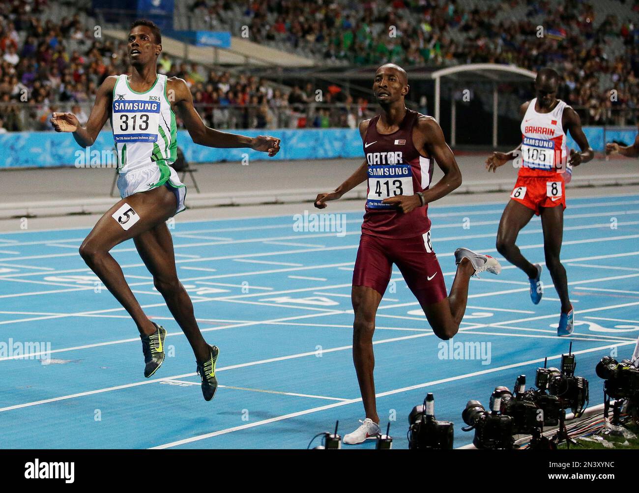 Saudi Arabia's Abdulaziz Ladan Mohammed, left, crosses the finish line ...