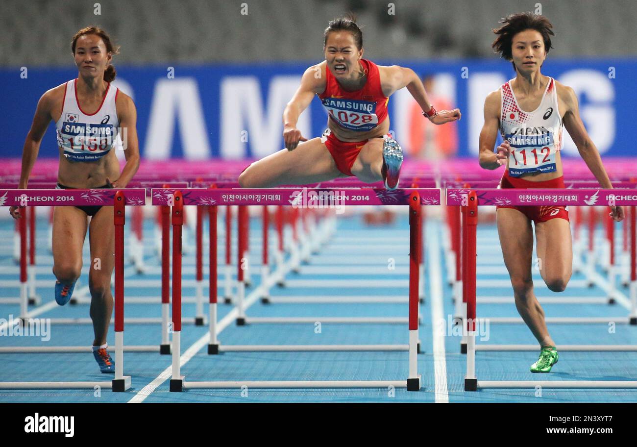 China's Wu Shuijiao, center, leads in the women's 100m hurdles final at ...