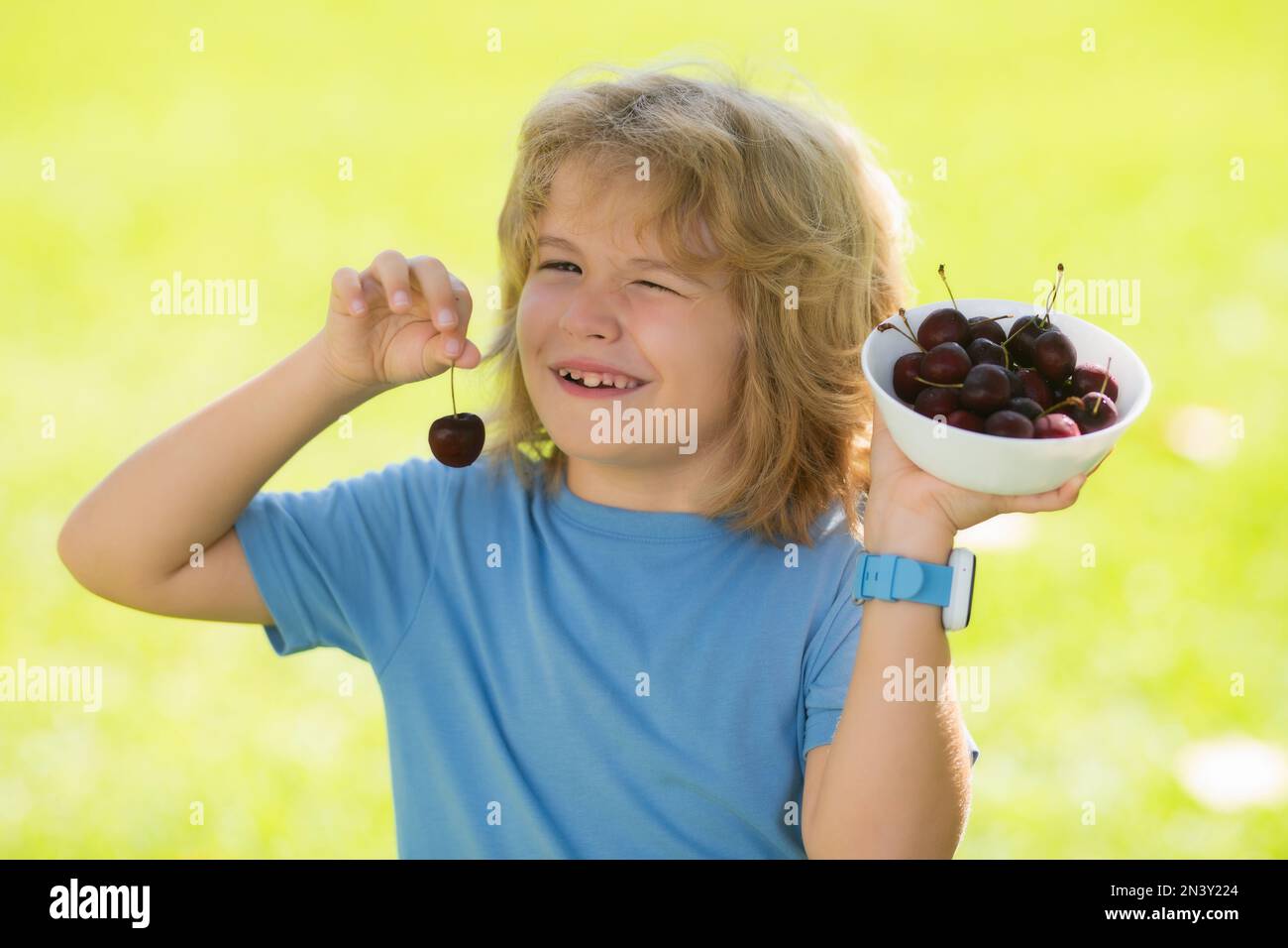 Cherry and cute child. The child eats cherries. Excited face. Cherry ...