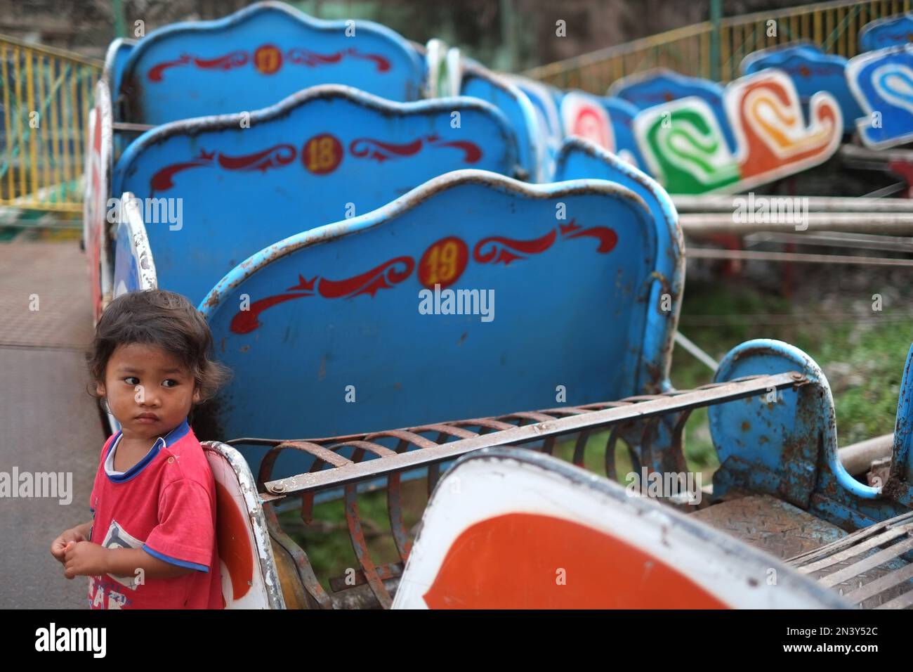 A Filipino girl leans on a carnival ride as they wait for visitors at a ...