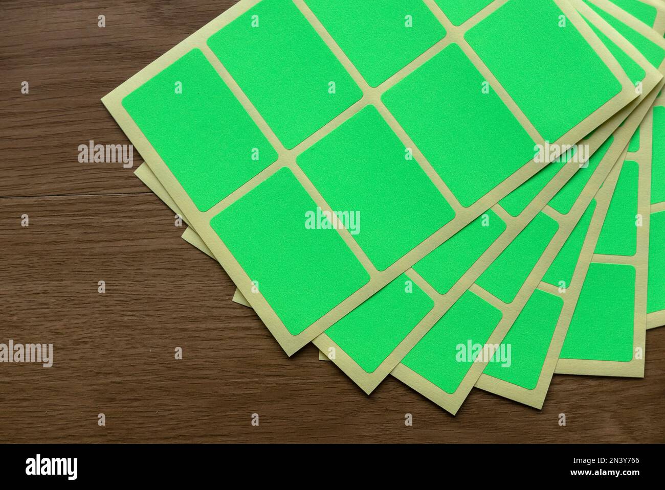 A set of green rectangular paper sticker label on wooden background ...