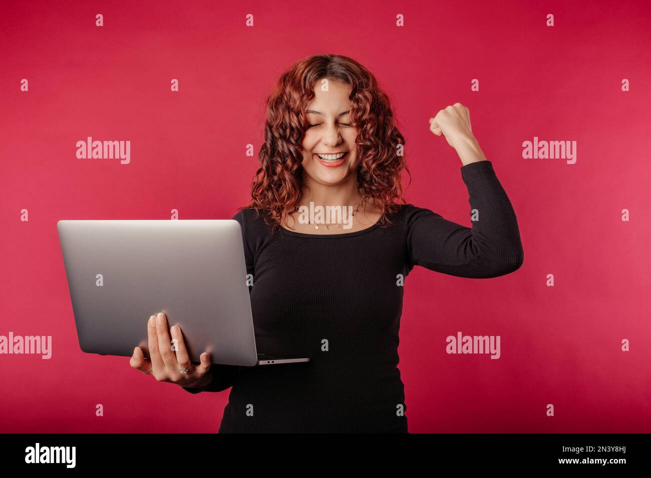 Portrait of cheerful woman wearing black ribbed dress standing isolated ...