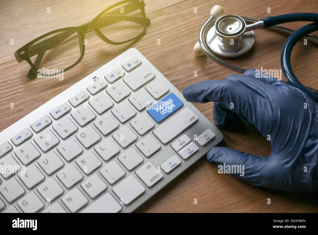 A hand wearing a blue glove pointing a finger to a blue computer ...