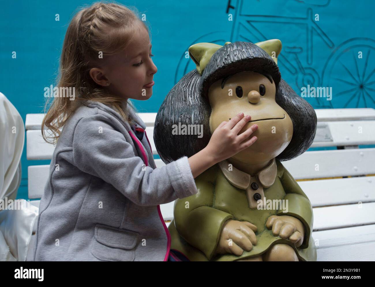 A girl caresses a statue of Mafalda, the main character of the comic ...