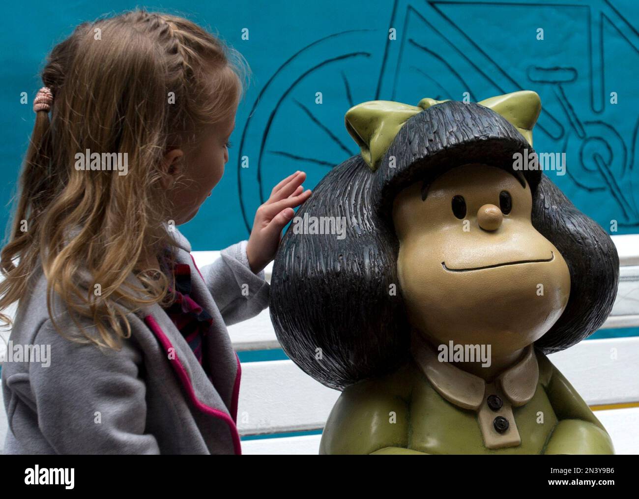A girl caresses a statue of Mafalda, the main character of the comic ...