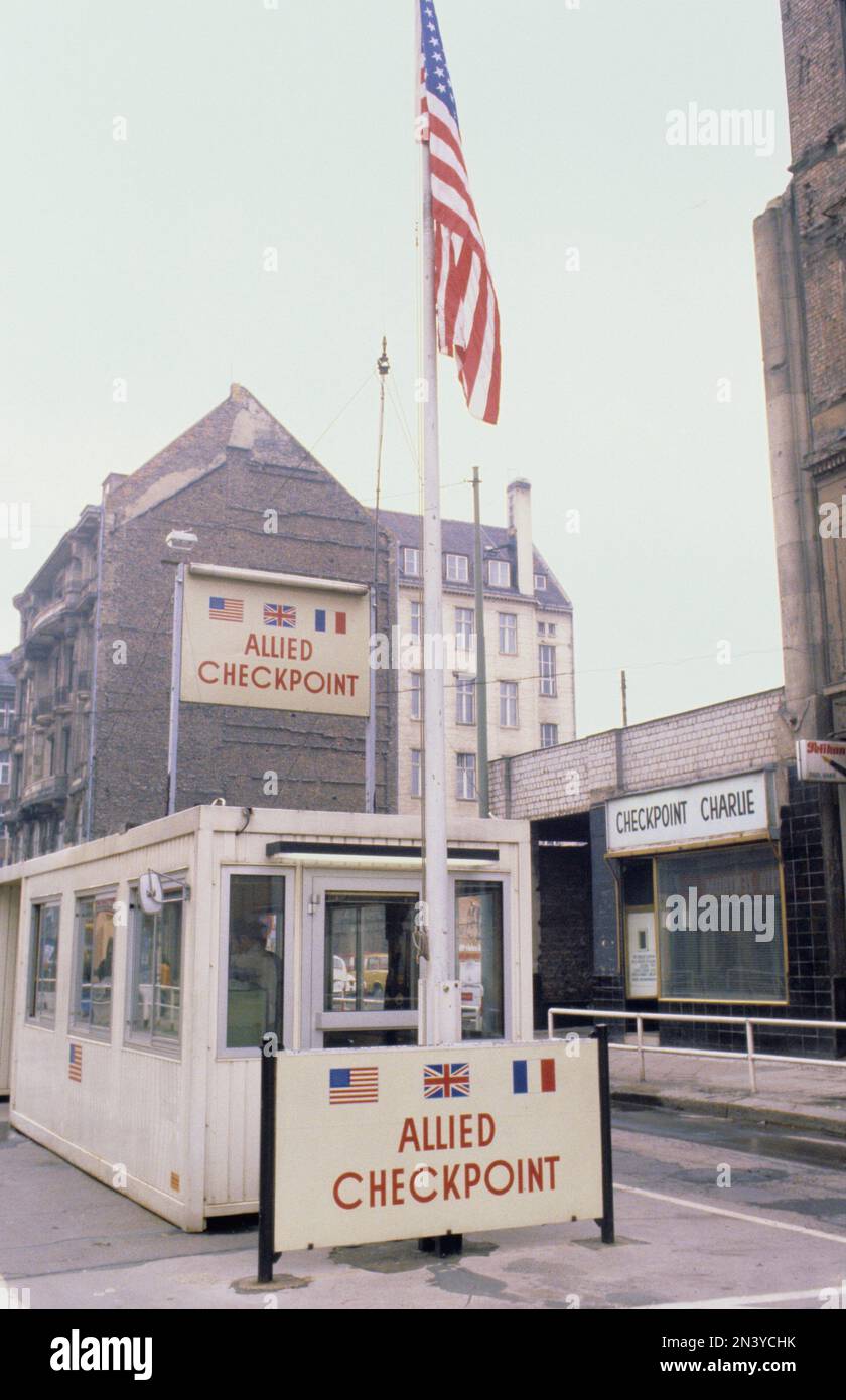 The Berlin Wall. A guarded concrete barrier that encircled West Berlin ...