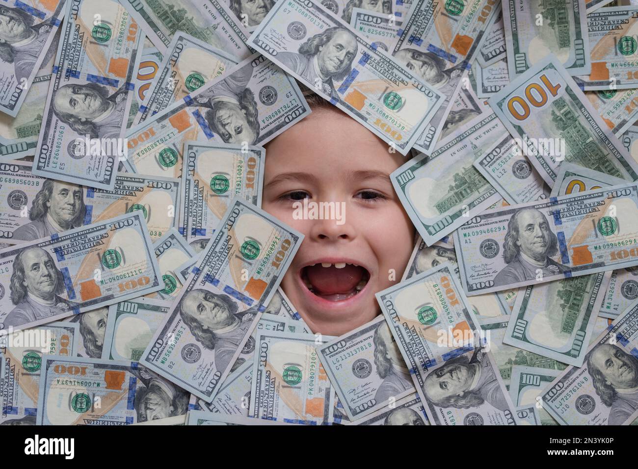Funny child with fun face with money. Kid peeking out of dollar bills ...