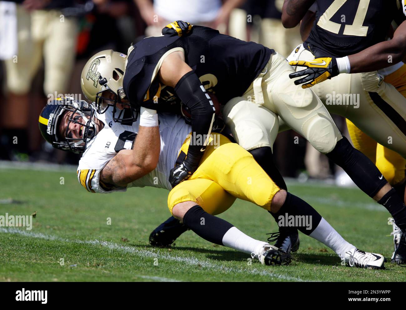 Iowa defensive back John Lowdermilk, bottom, tackles Purdue tight end ...