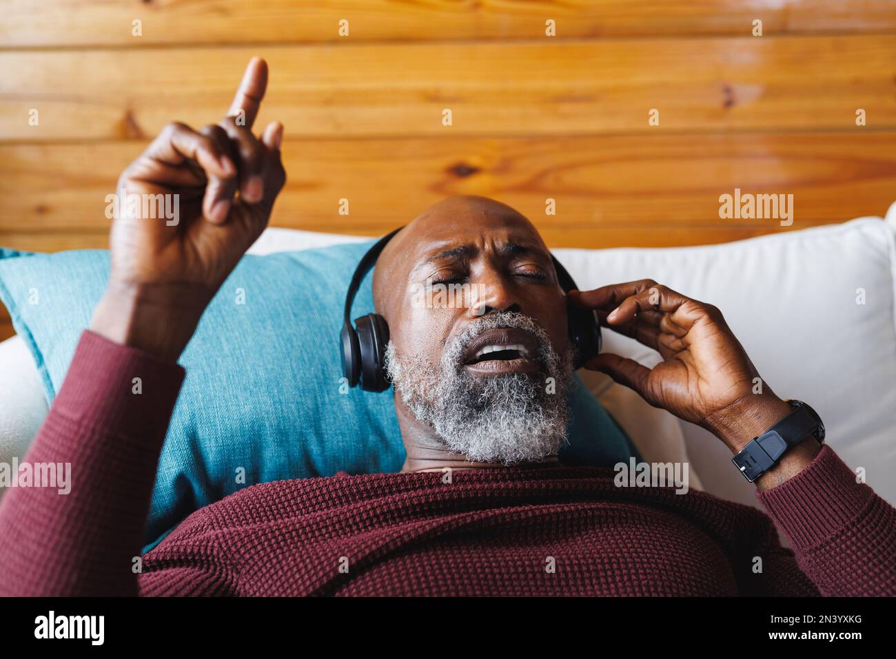 African American Senior Man Listening Music And Singing While Lying On