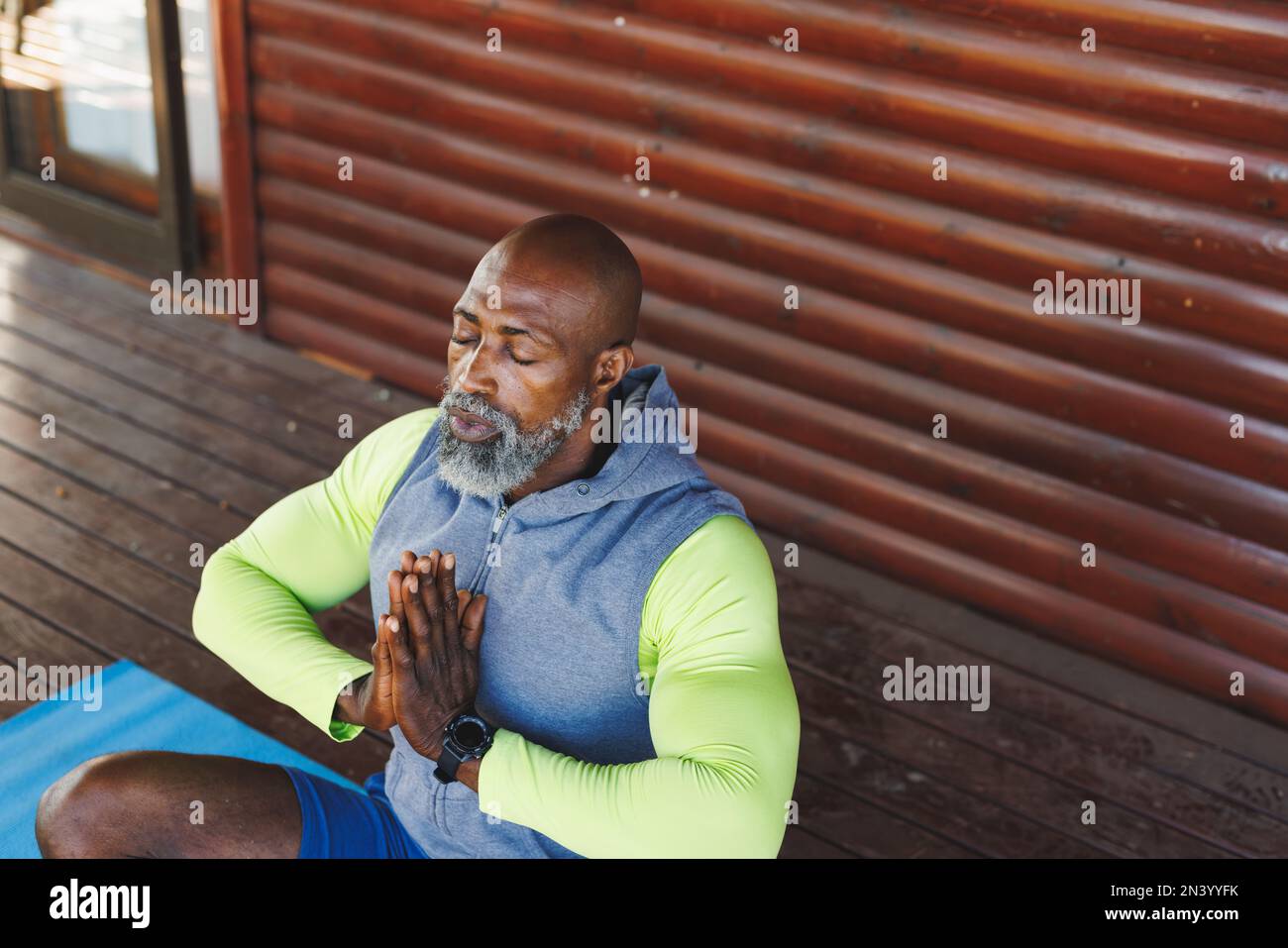 High angle view of african american bald senior man meditating in ...
