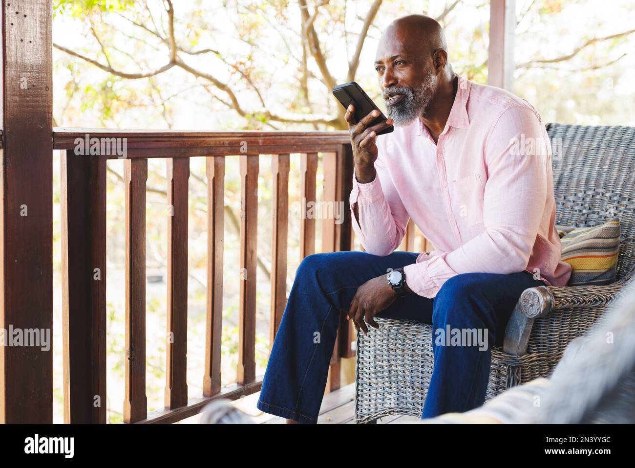 African american senior man sending voicemail over mobile phone while ...