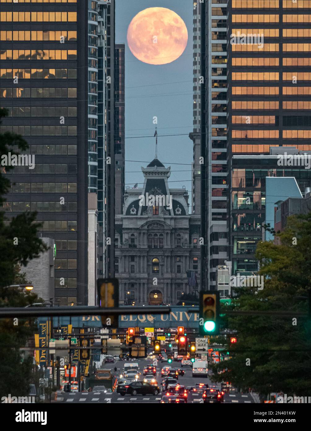 A scenic shot of the full moon rising above the City Hall in ...