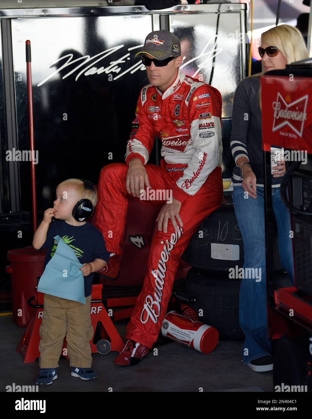 Driver Kevin Harvick, center, looks from in the garage area with his ...