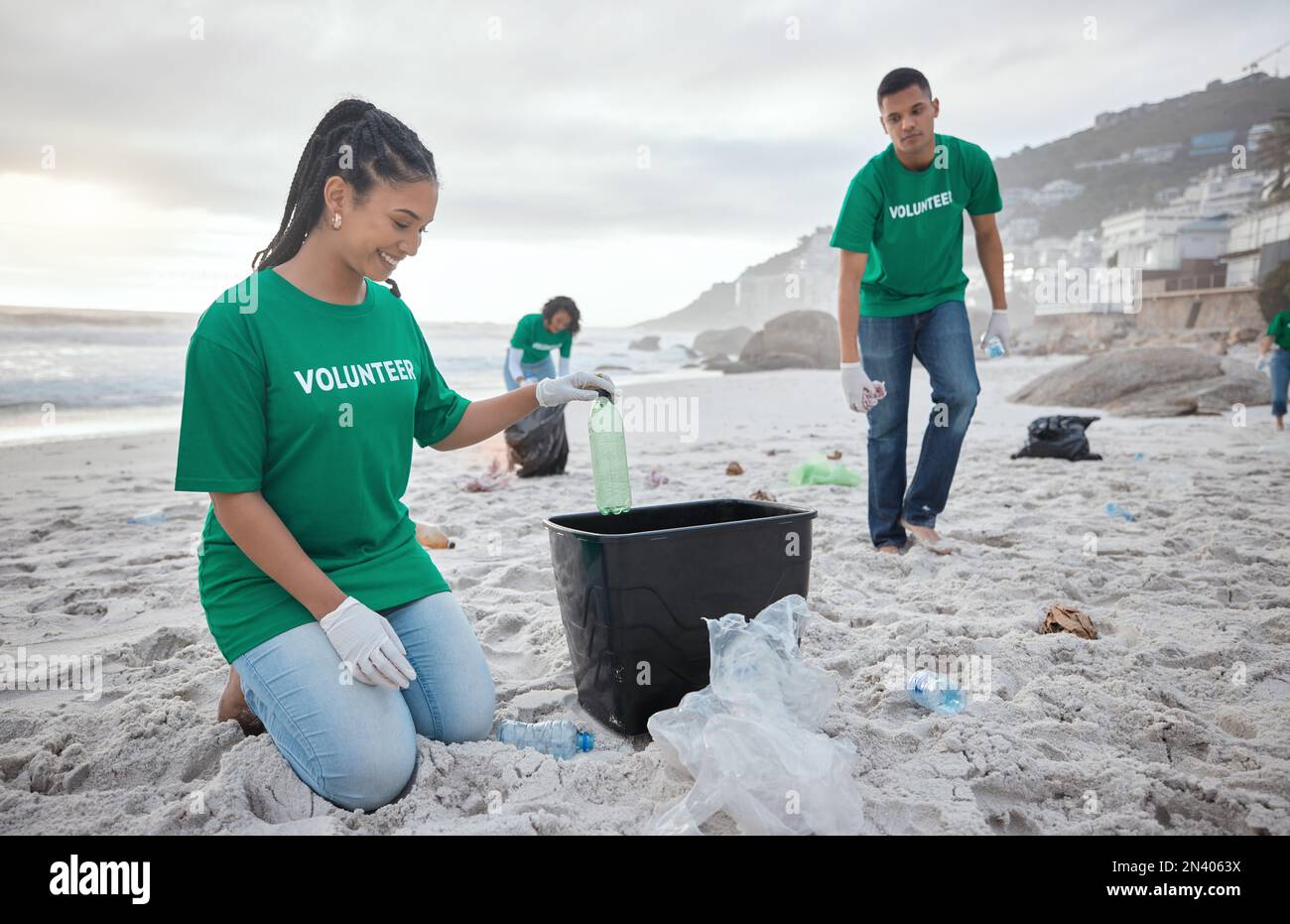 Teamwork, cleaning and recycling with people on beach for ...