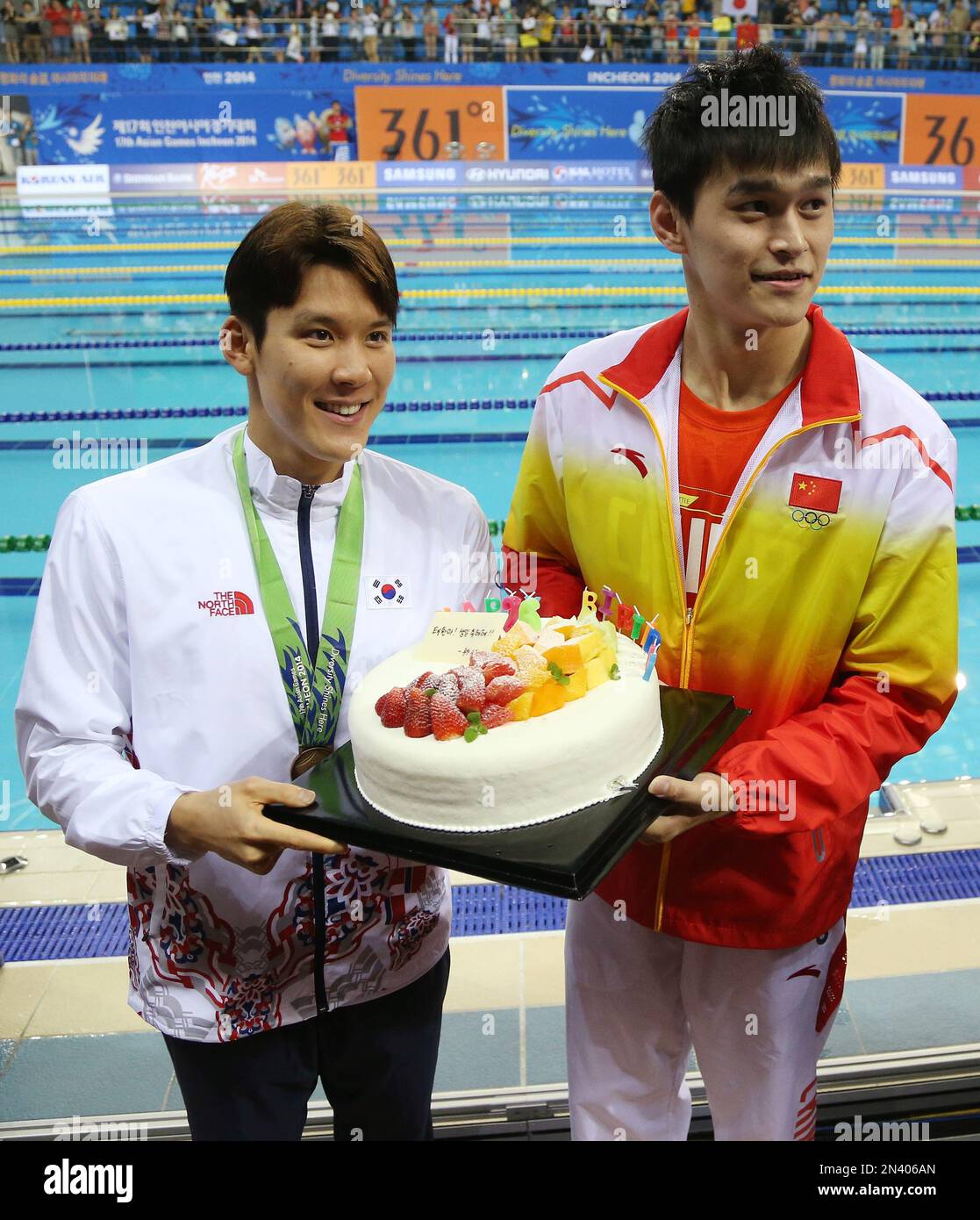 China's Sun Yang, right, presents a birthday cake to South Korean rival ...