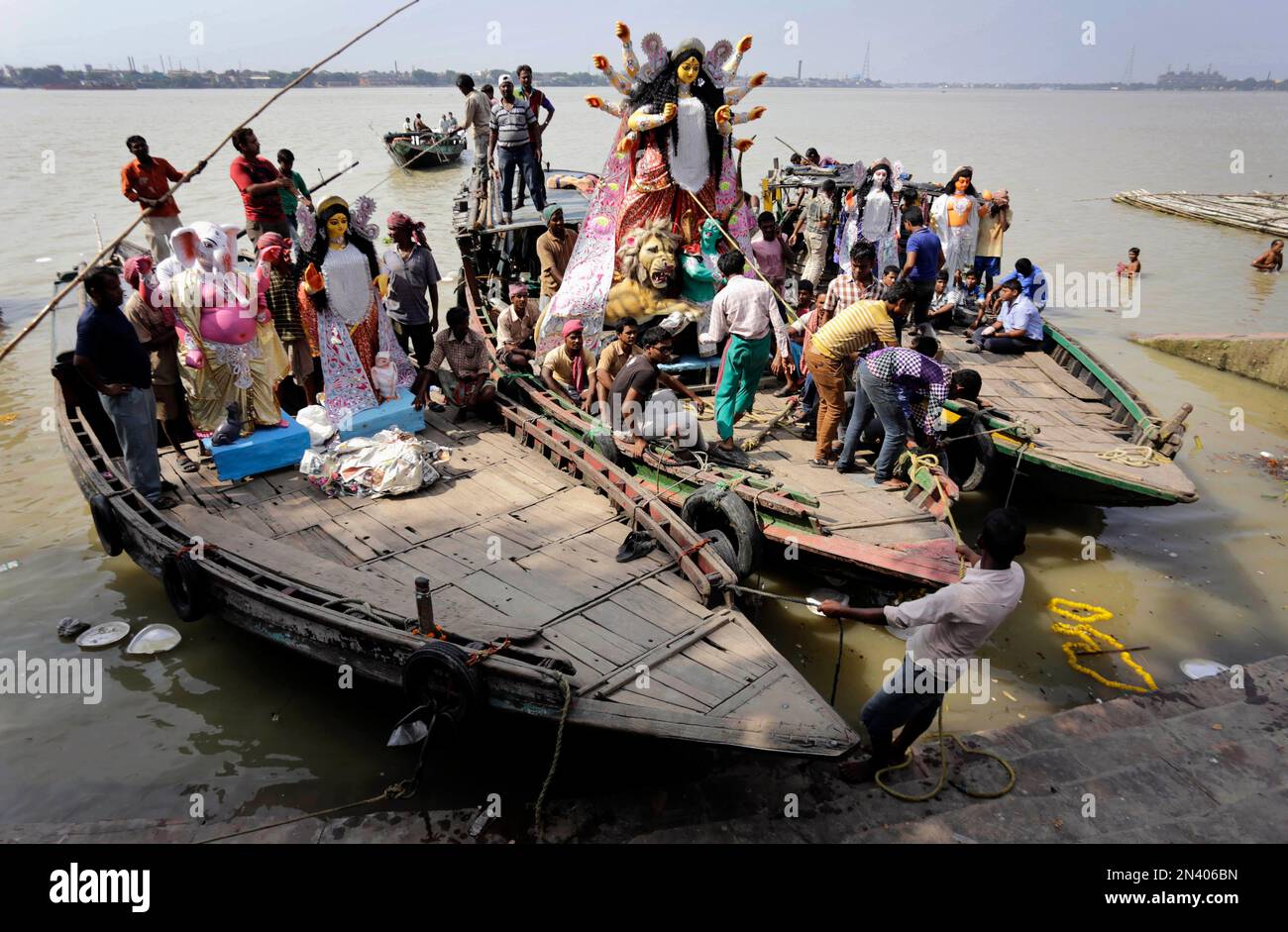 Idols of Hindu goddess Durga is carried on a country boat on the Ganges ...