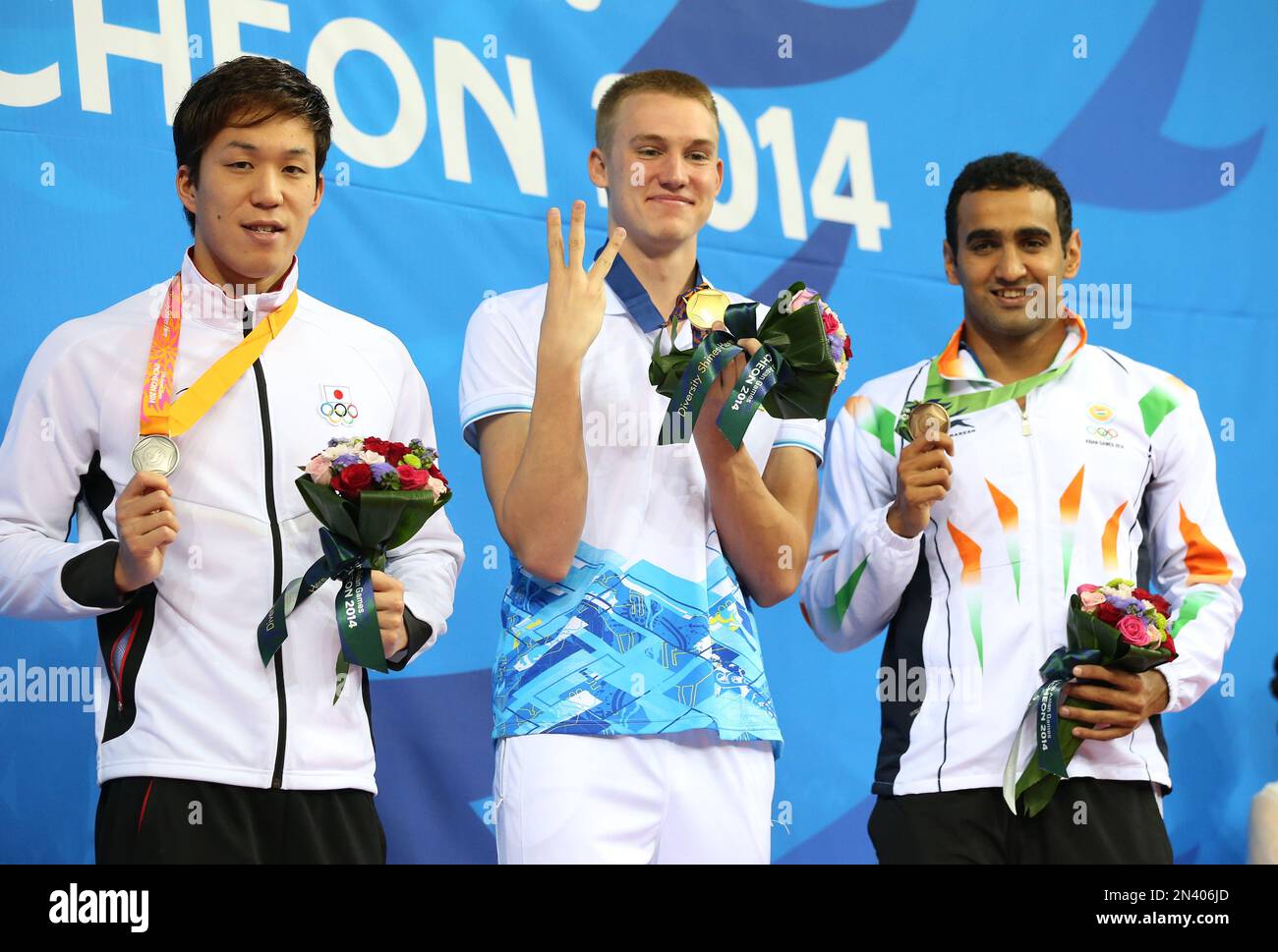 Kazakhstan's Dmitriy Balandin, centre, gestures on the podium with his ...