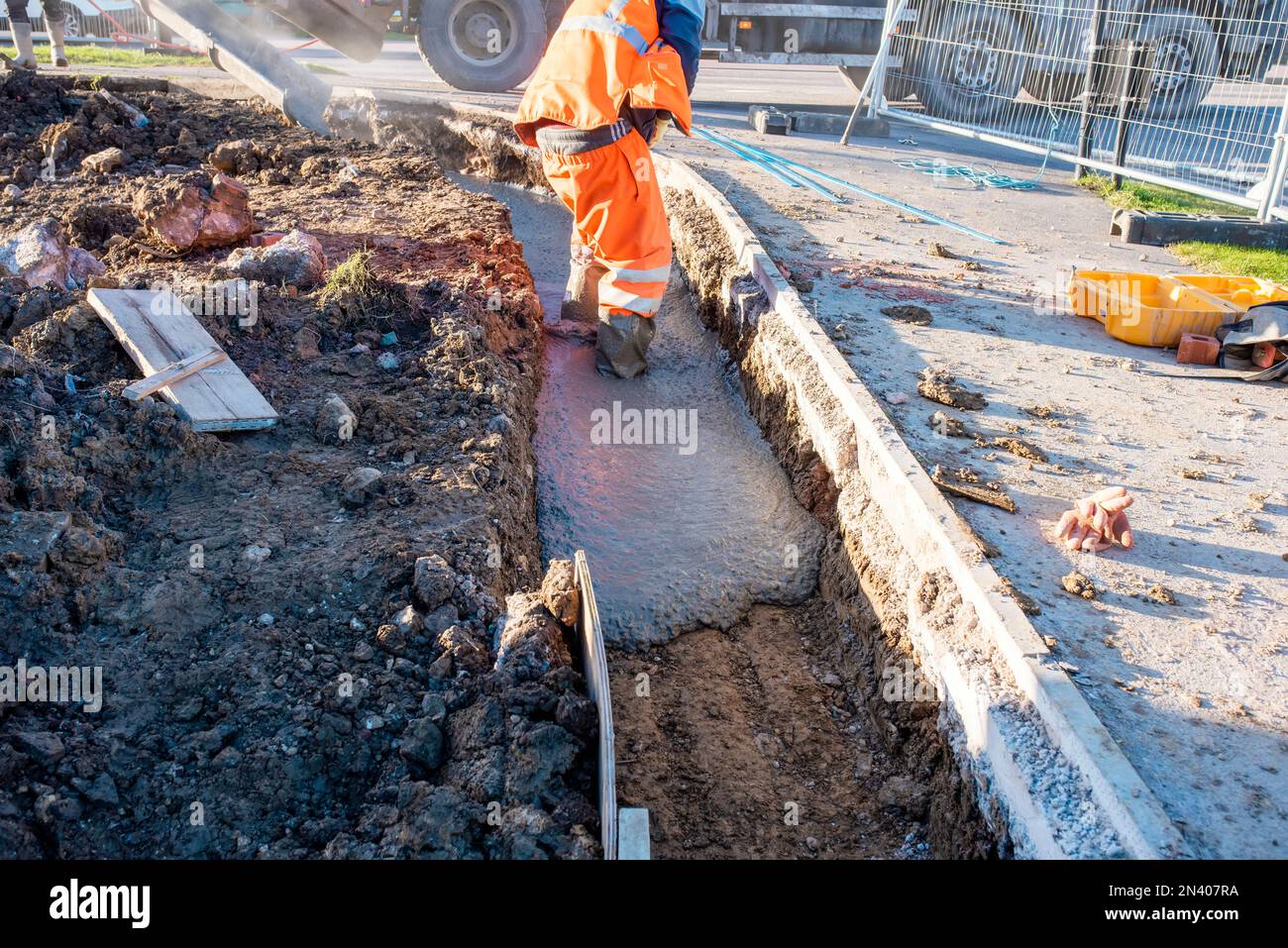 Builder pouring wall foundation with wet ready-mix concrete, levelling ...