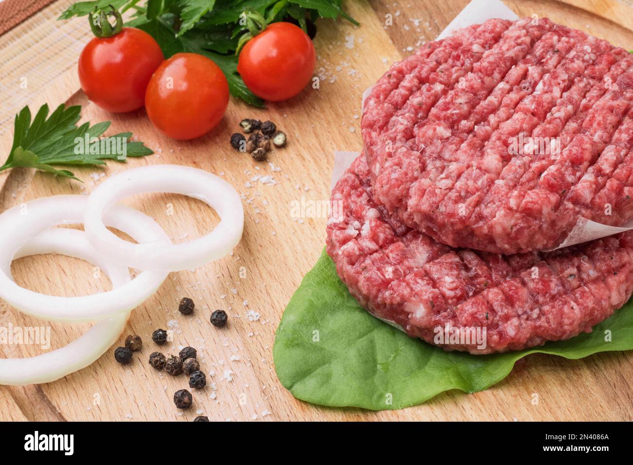 Raw Ground beef meat Burger steak cutlets on a wooden board background ...