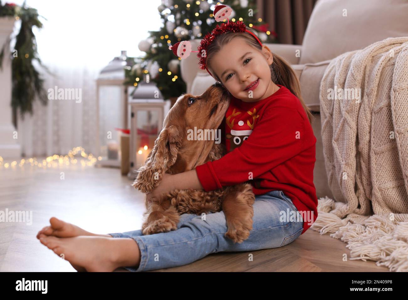 Cute little girl with English Cocker Spaniel in room decorated for ...